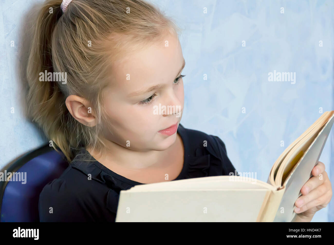 Image of cute girl reading a book Stock Photo - Alamy