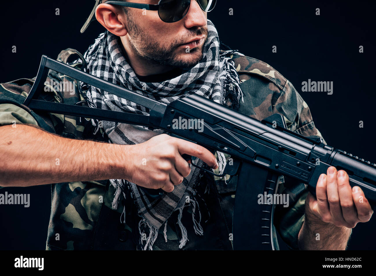 Portrait of terrorist with gun on aim on black background Stock Photo ...