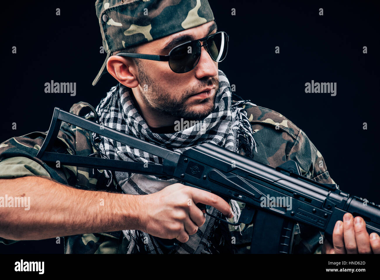 Portrait of terrorist with gun on aim on black background Stock Photo ...