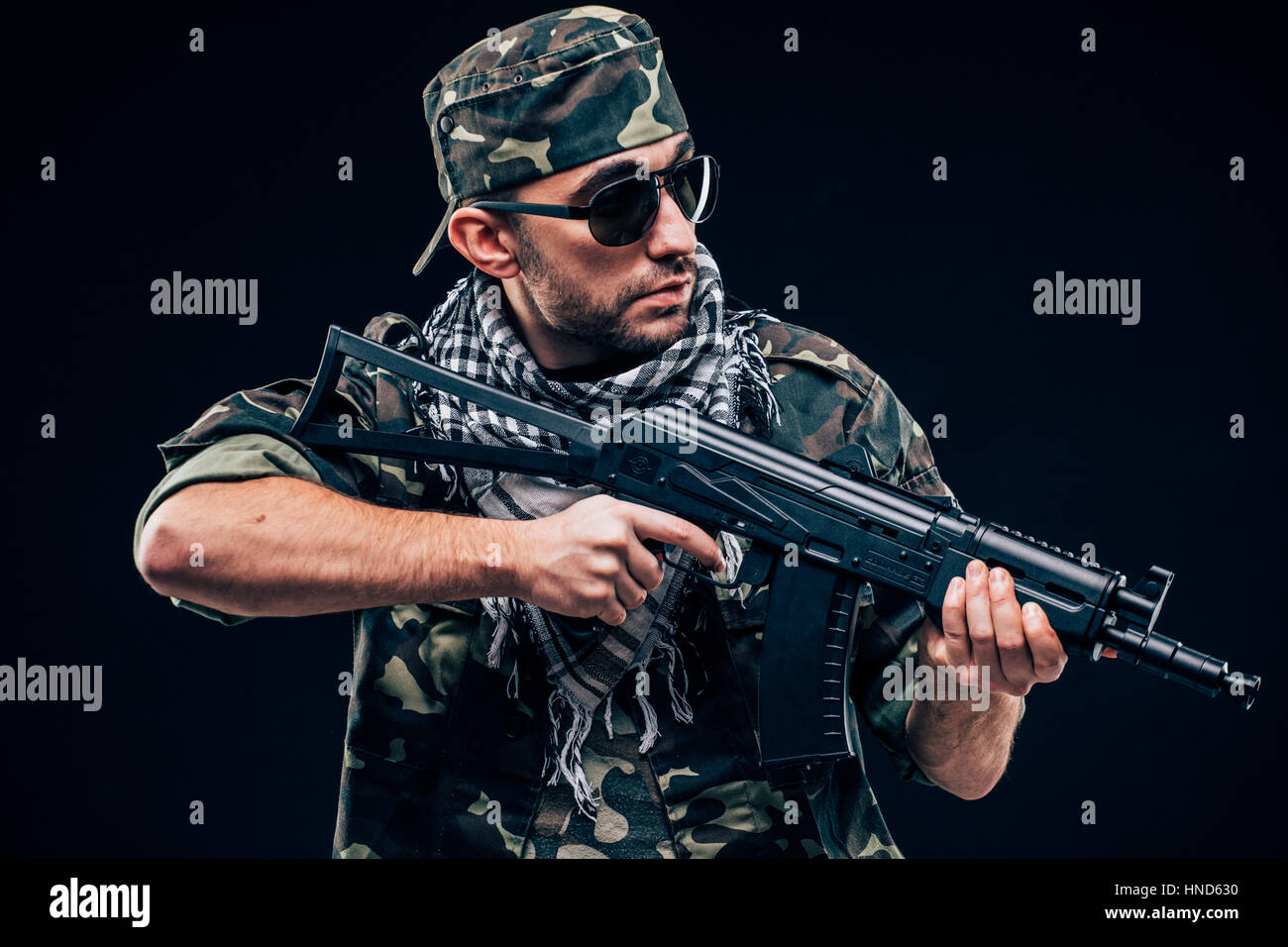 Portrait of terrorist with gun on aim on black background Stock Photo ...