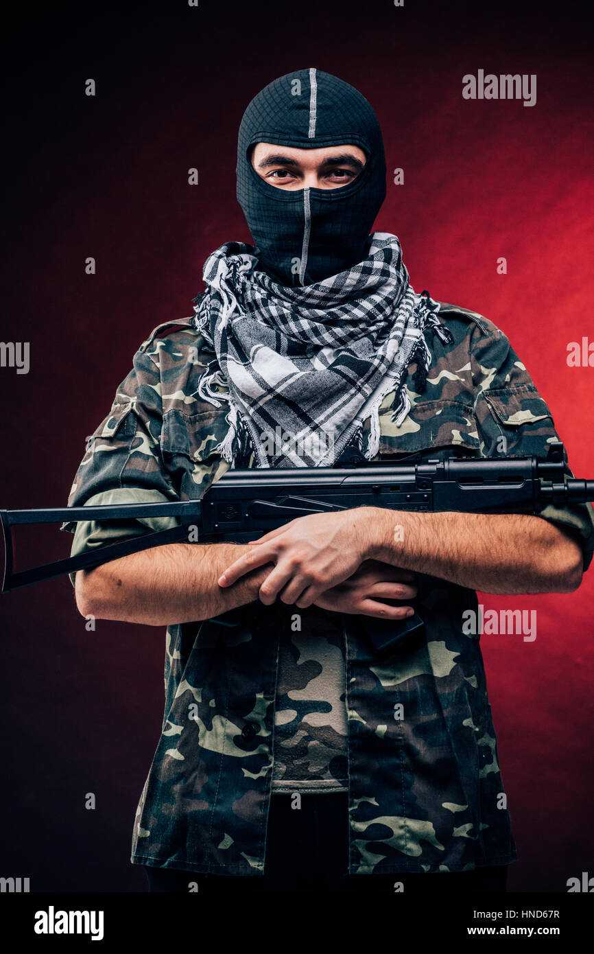 Terrorist with weapon aim on red background Stock Photo - Alamy