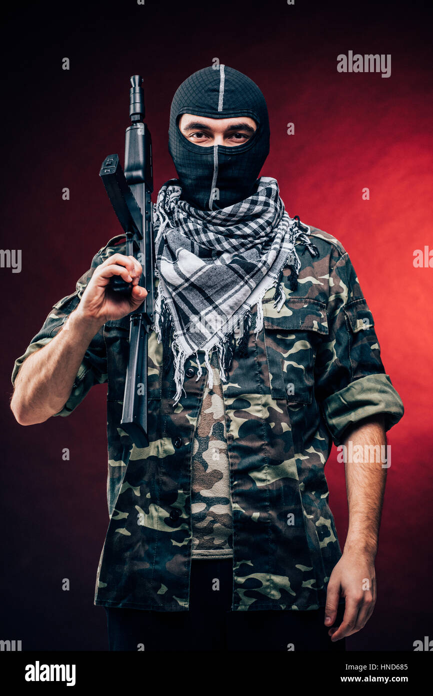 Terrorist with weapon aim on red background Stock Photo - Alamy