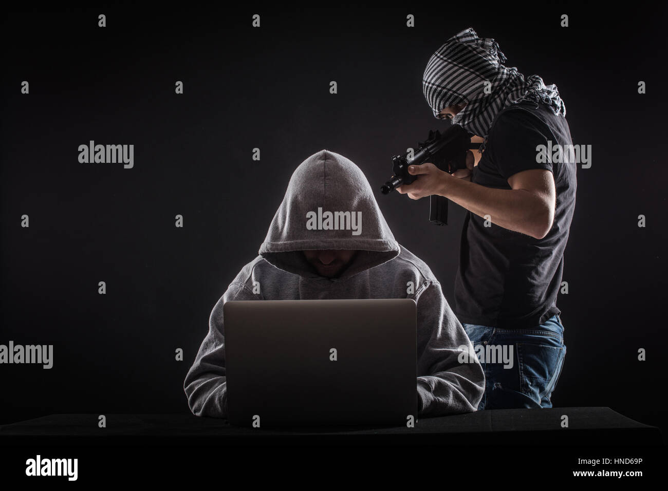 Terrorist attack hacker with gun work at laptop Stock Photo - Alamy