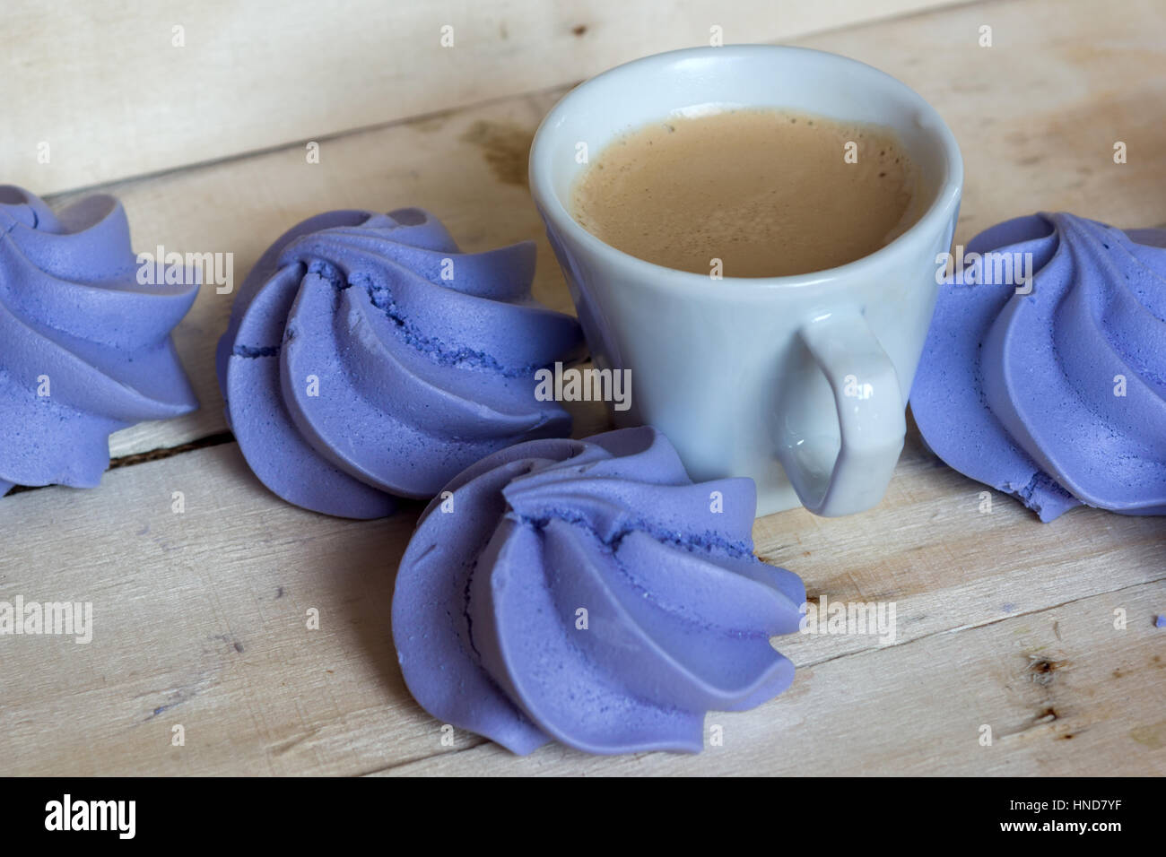French blue meringue cookies and cup of coffee on white wooden ...