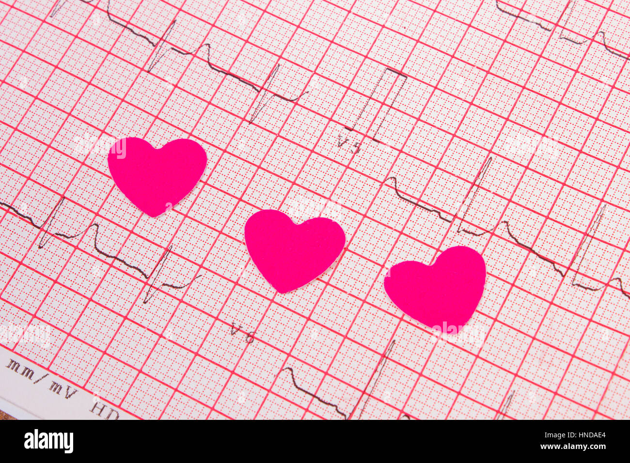 Hearts of paper lying on electrocardiogram graph, ecg heart rhythm ...