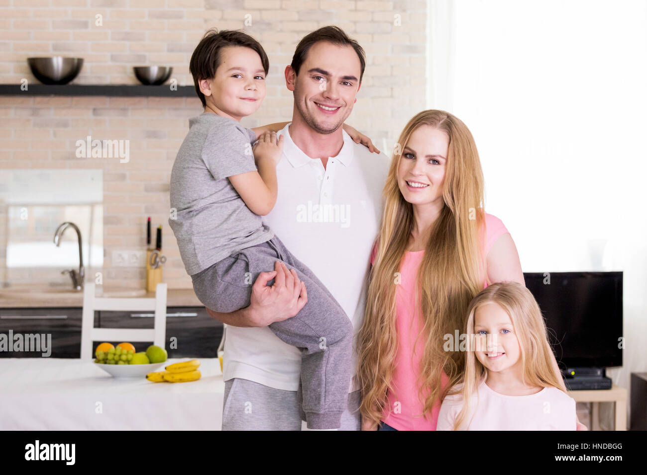 Portrait of happy family with two children at home Stock Photo - Alamy