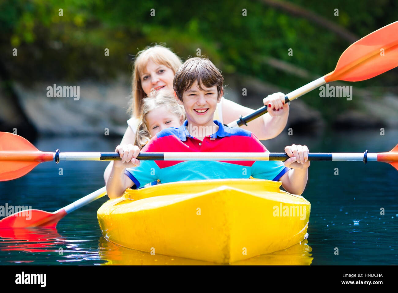 Happy family with two kids enjoying kayak ride on beautiful river ...