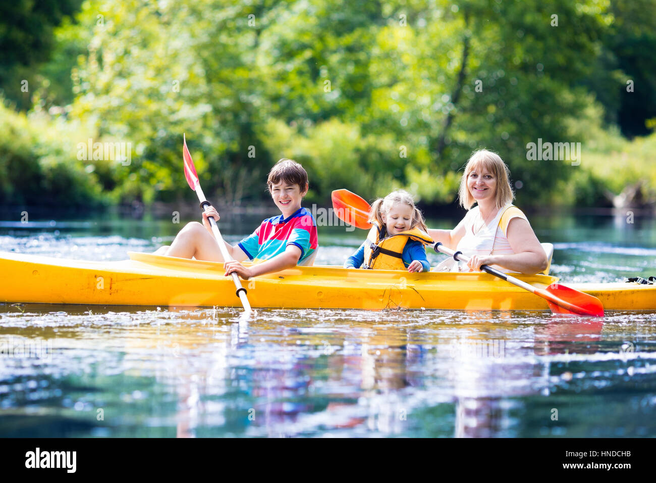 Happy family with two kids enjoying kayak ride on beautiful river ...
