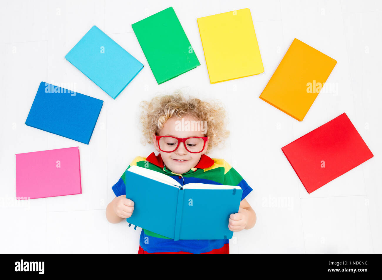 Little boy with colorful rainbow books. Happy back to school student ...