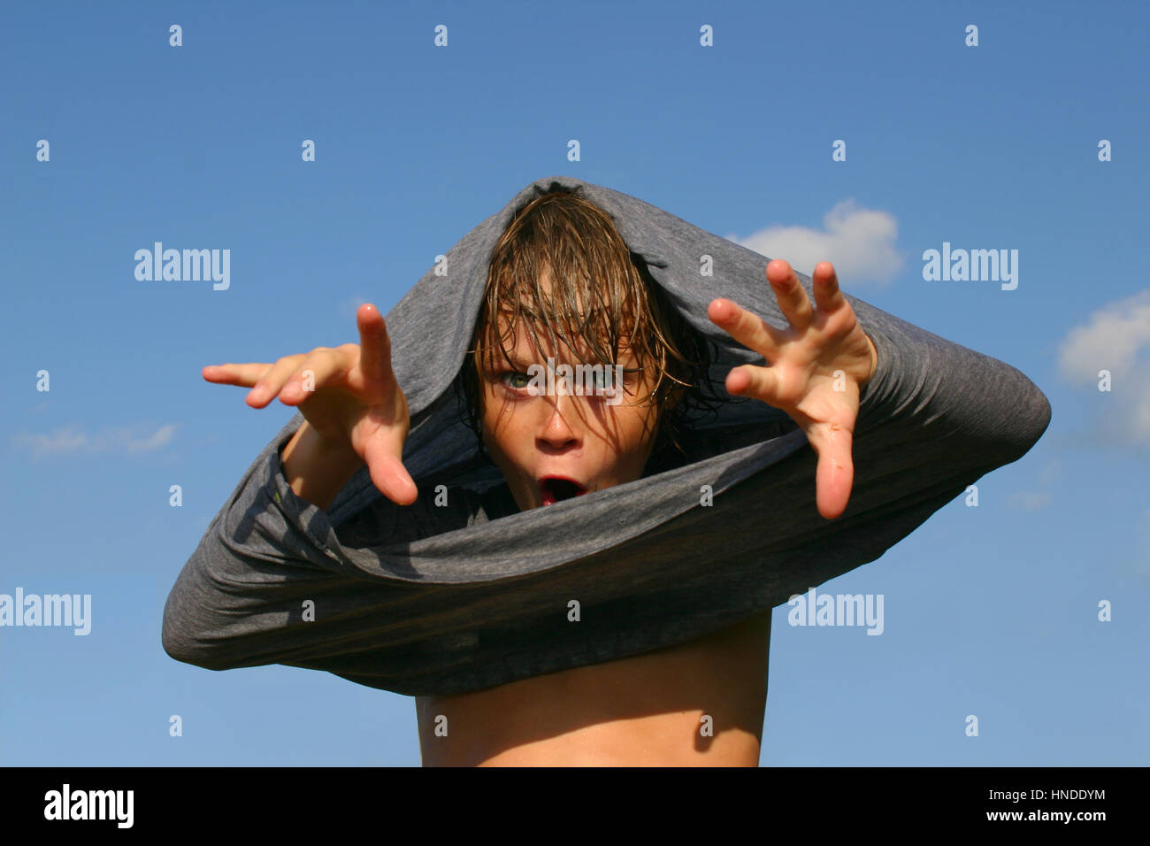 a teen boy with his shirt pulled up over his head making a silly face ...