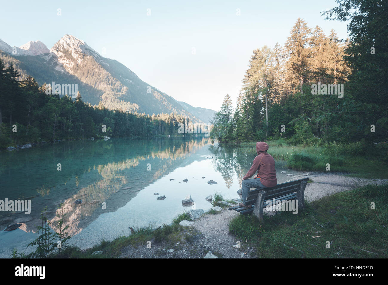 Man sitting near the mountain lake Stock Photo - Alamy