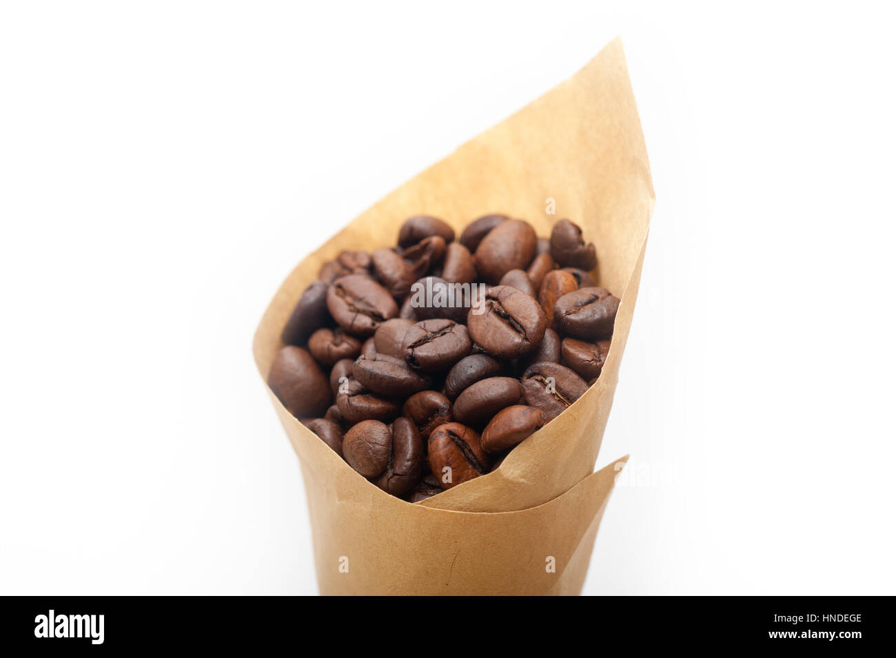 espresso coffee beans on a paper cone cornucopia over white background ...
