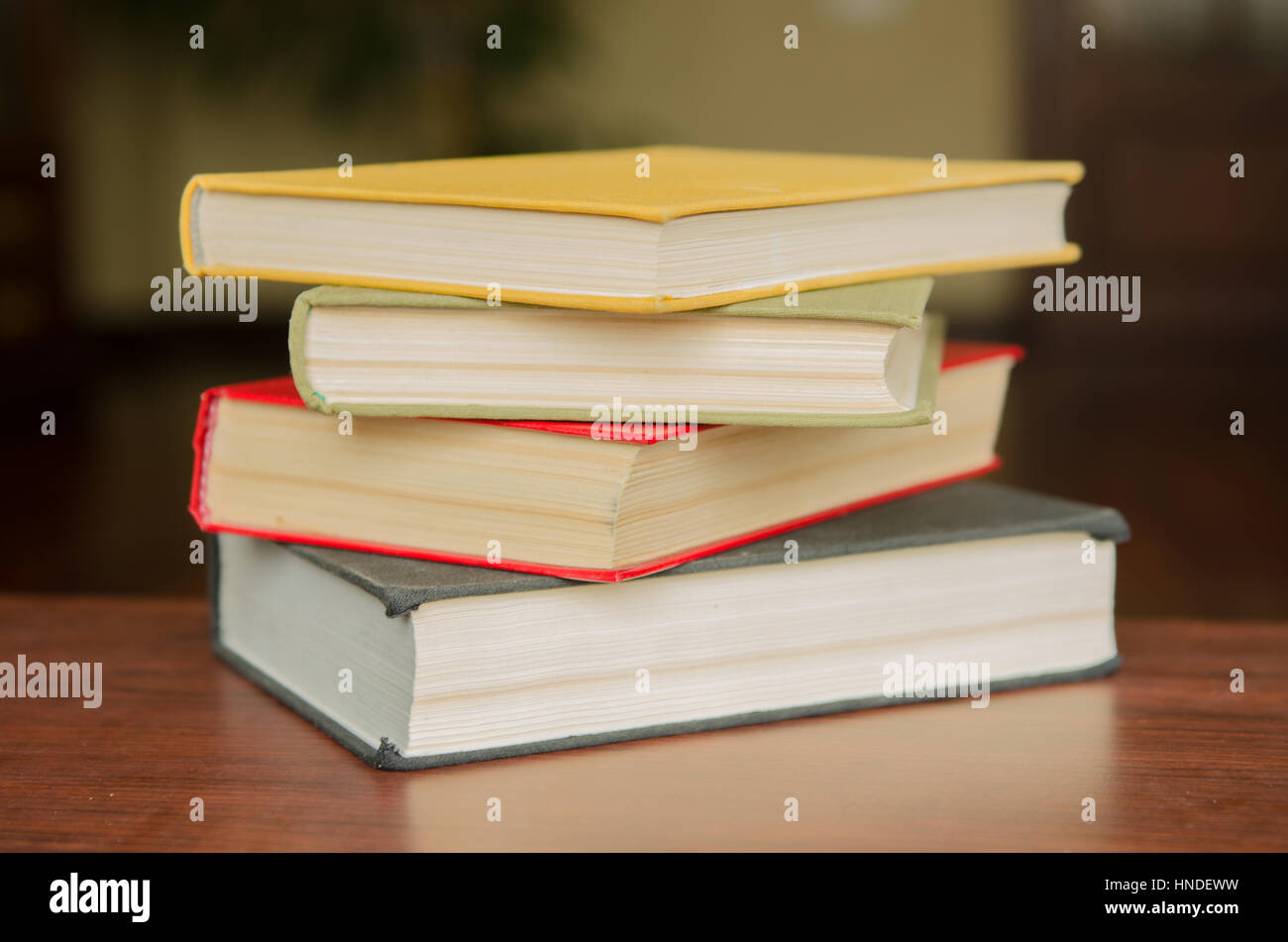 a stack of colorful books in a library or a room Stock Photo - Alamy