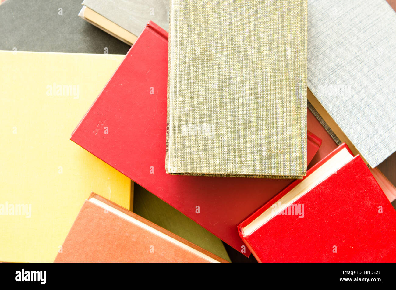 a stack of colorful books in a library or a room Stock Photo - Alamy