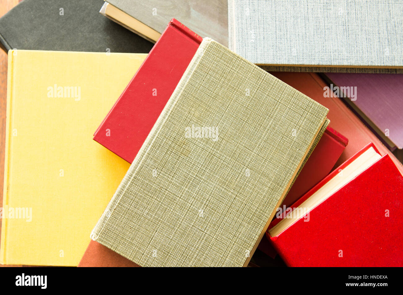 a stack of colorful books in a library or a room Stock Photo - Alamy