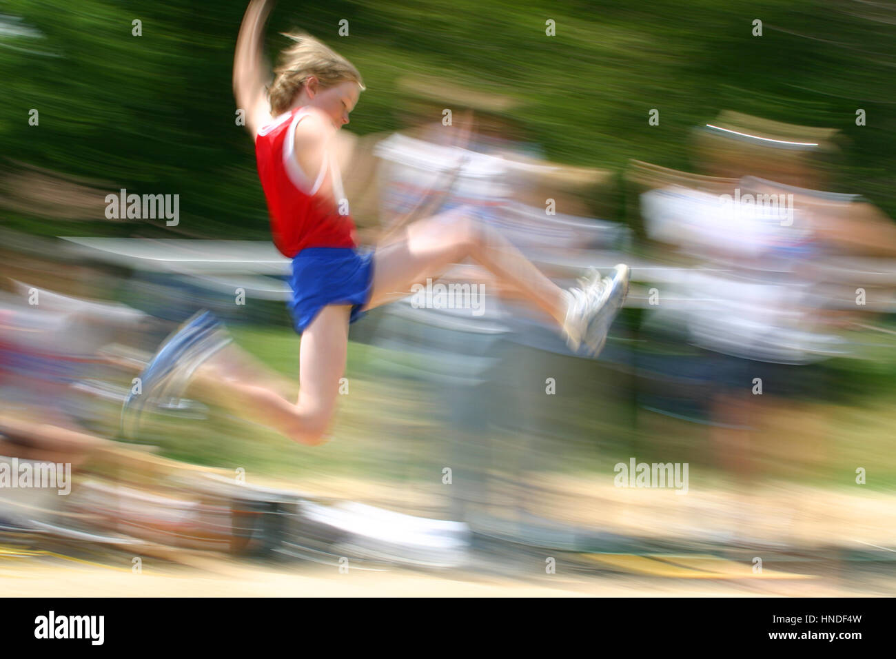teen boy jumping at a track meet Stock Photo - Alamy