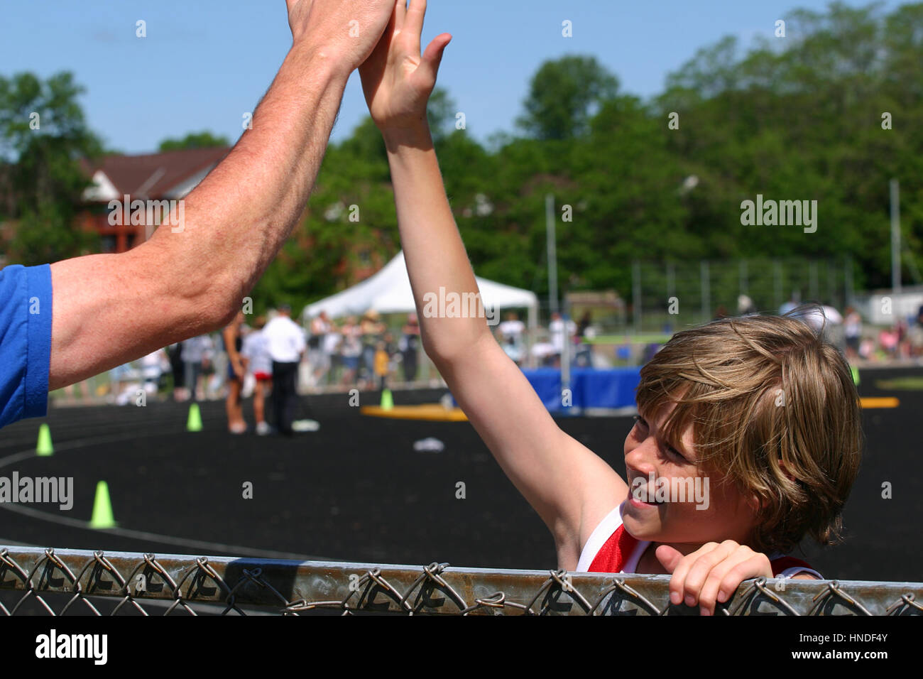 teen boy "High Fives" coach at track meeet Stock Photo - Alamy