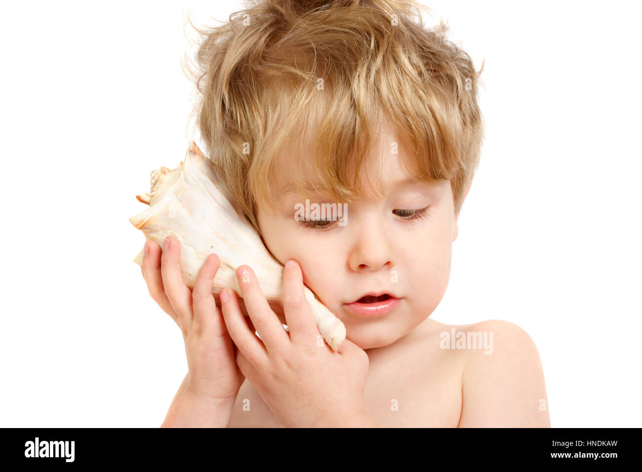 young boy listening to seashell Stock Photo - Alamy