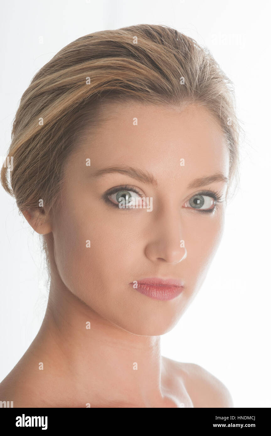 Beautiful young blonde woman staring against a white background Stock ...