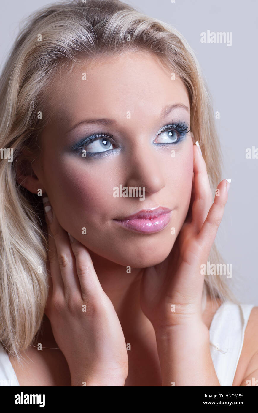 Young woman hands touching face looking away Stock Photo - Alamy