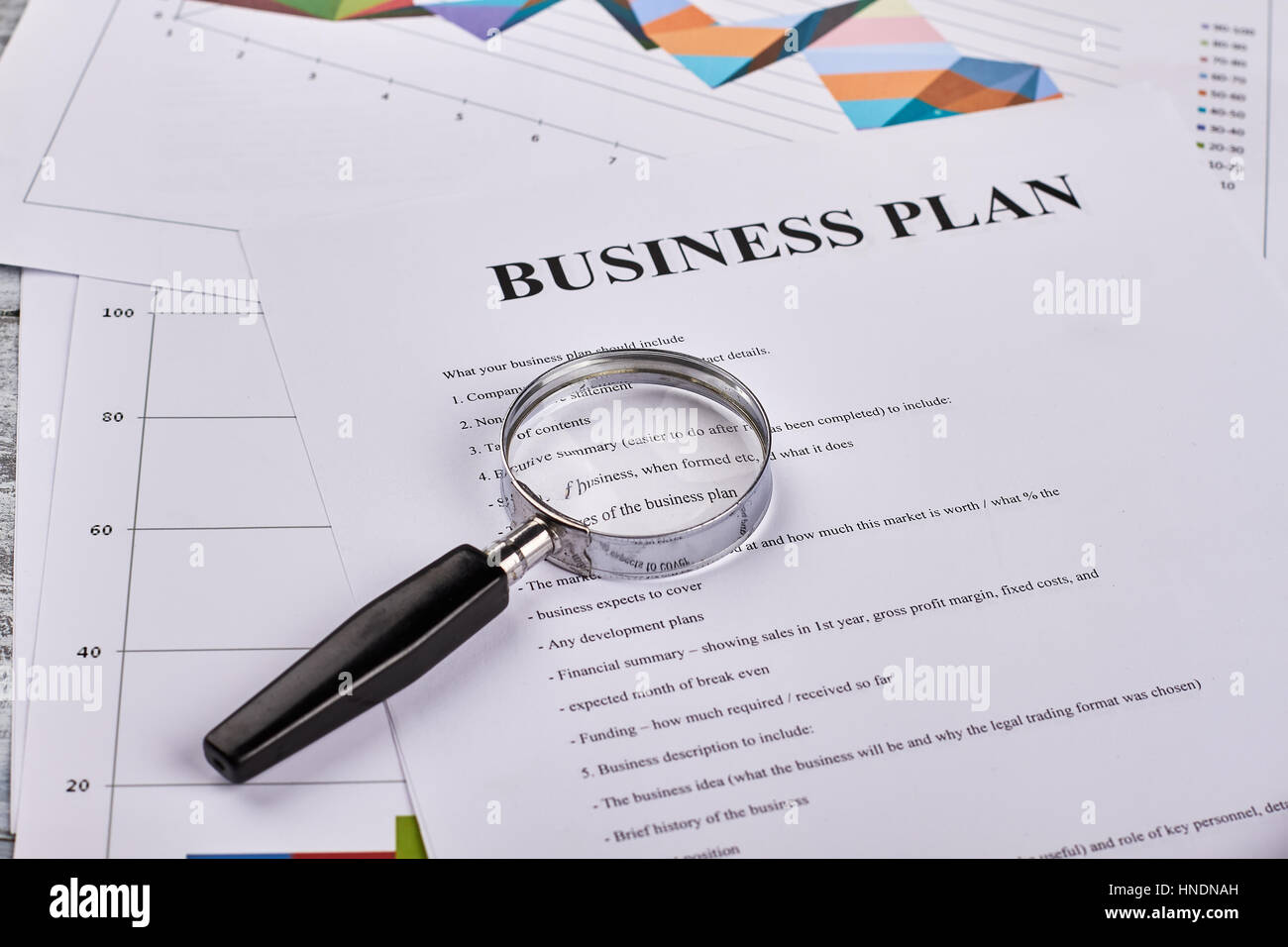 Magnifying glass and business documents Stock Photo - Alamy