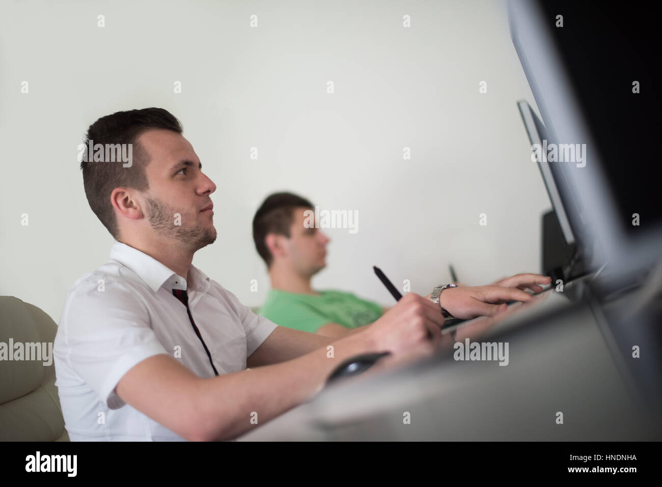 a group of young graphic designers working on a digital tablet and a ...