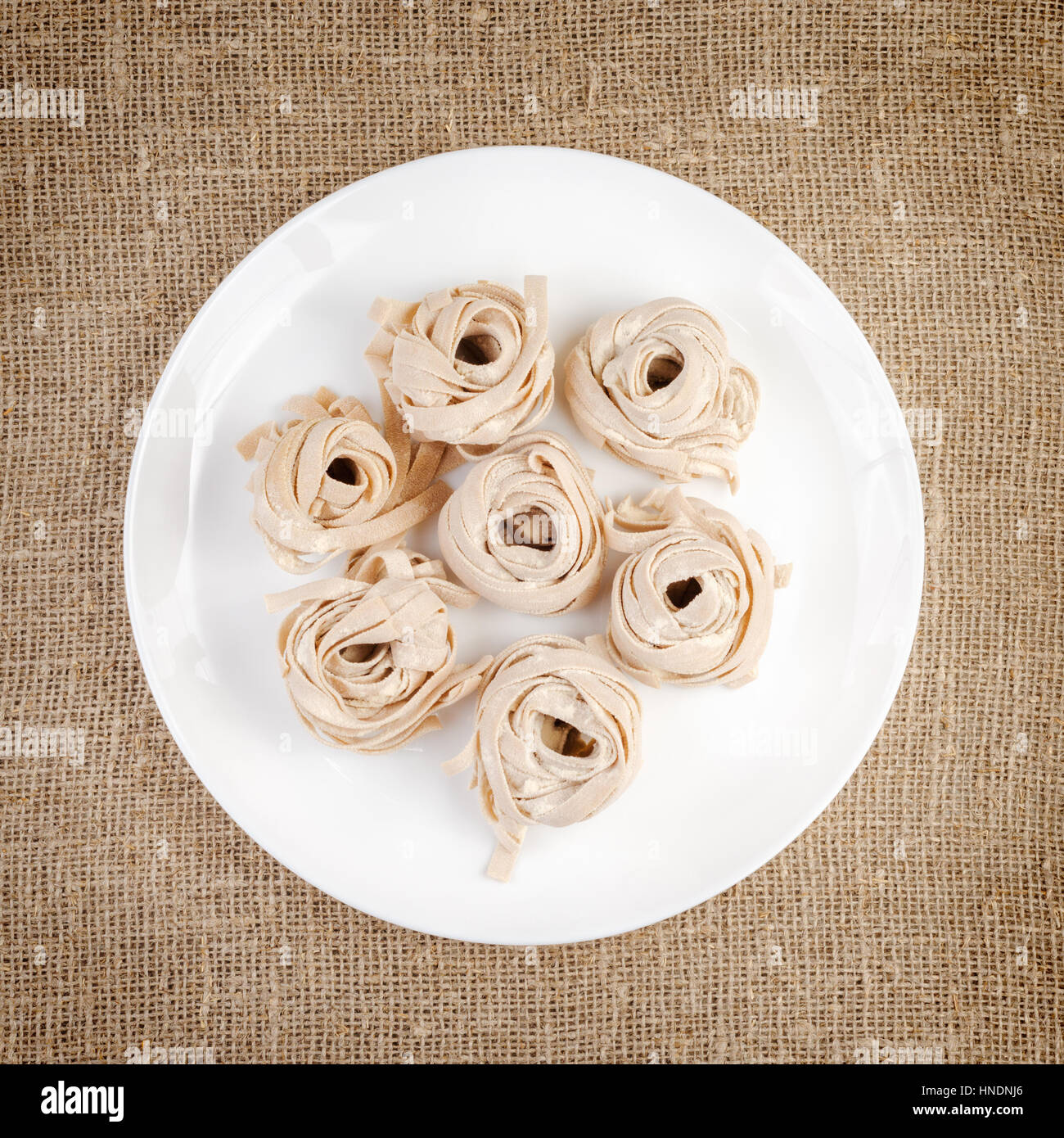 Homemade rolled pasta on linen background . Portion of raw fettuccine ...