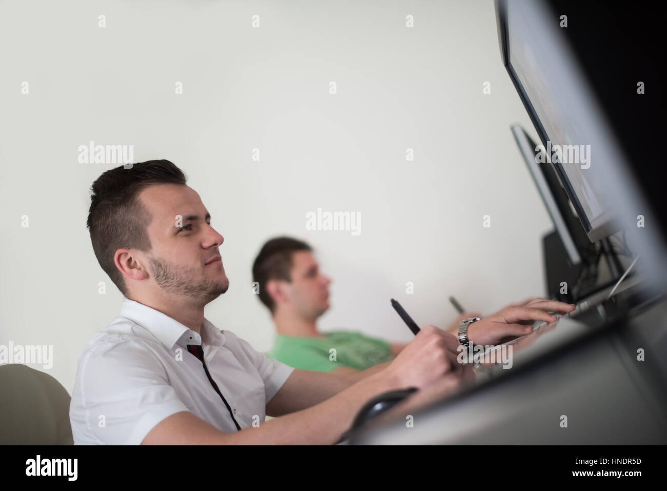 a group of young graphic designers working on a digital tablet and a ...
