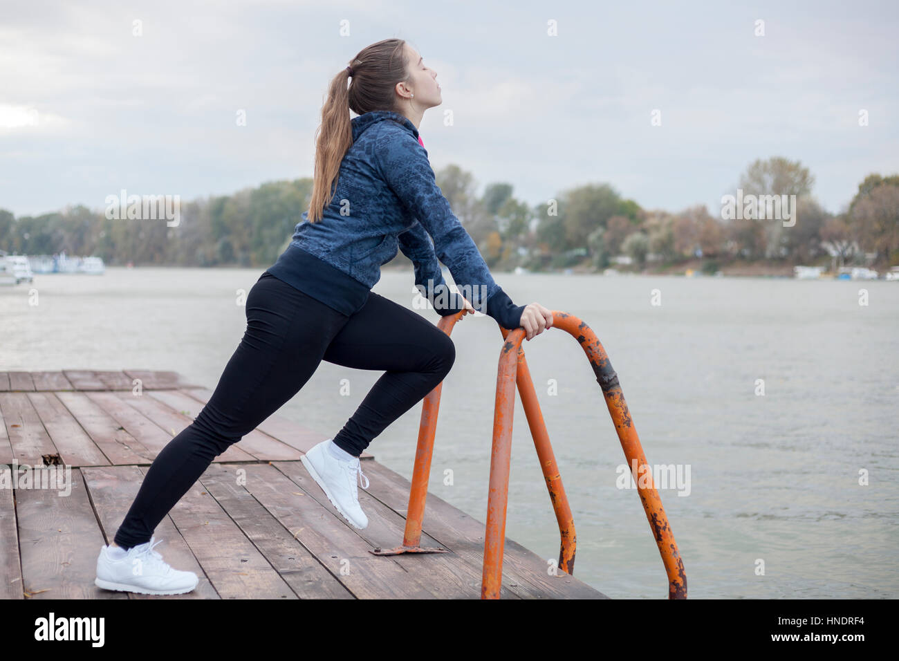 A young woman exercises by the river Stock Photo - Alamy