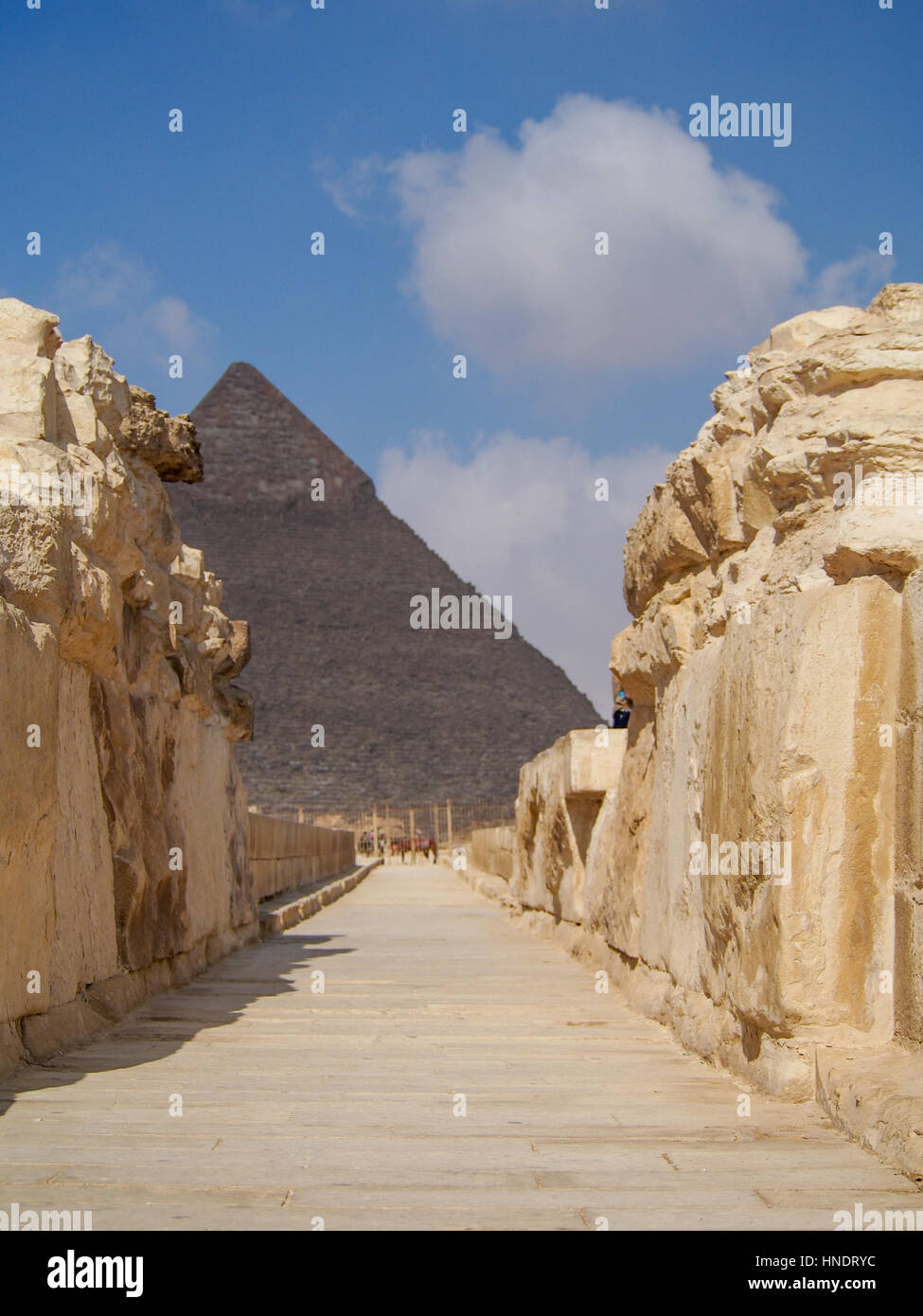 A pathway leads through ancient ruins to the Great Pyramids of Giza in ...