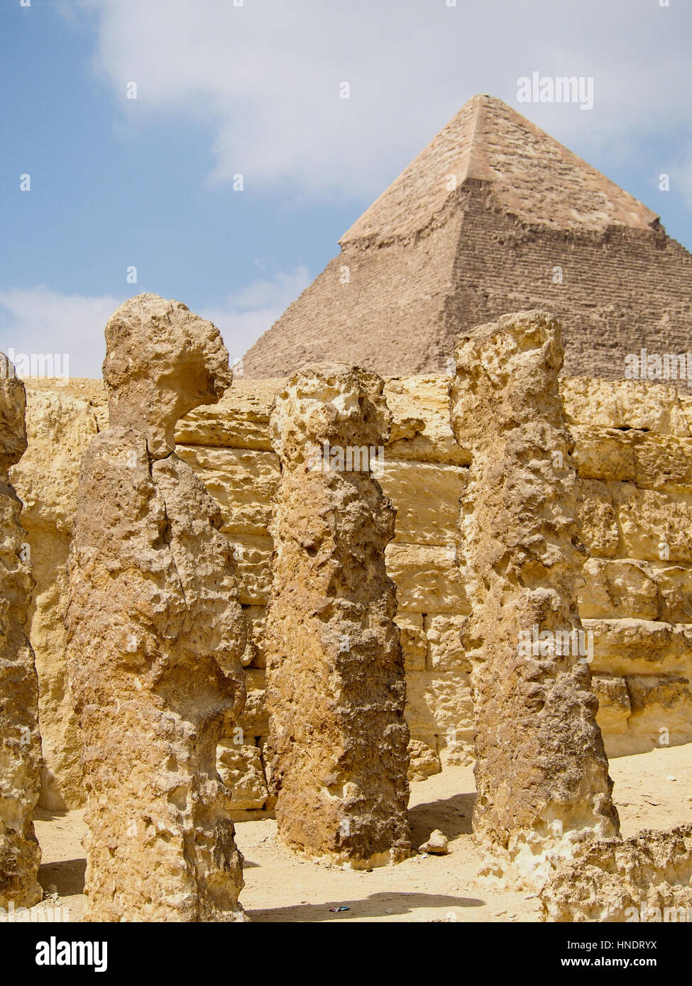 Ruins standing in front of the great pyramids of Giza in the desert ...
