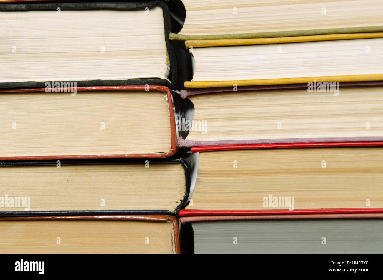 a stack of colorful books in a library or a room Stock Photo - Alamy