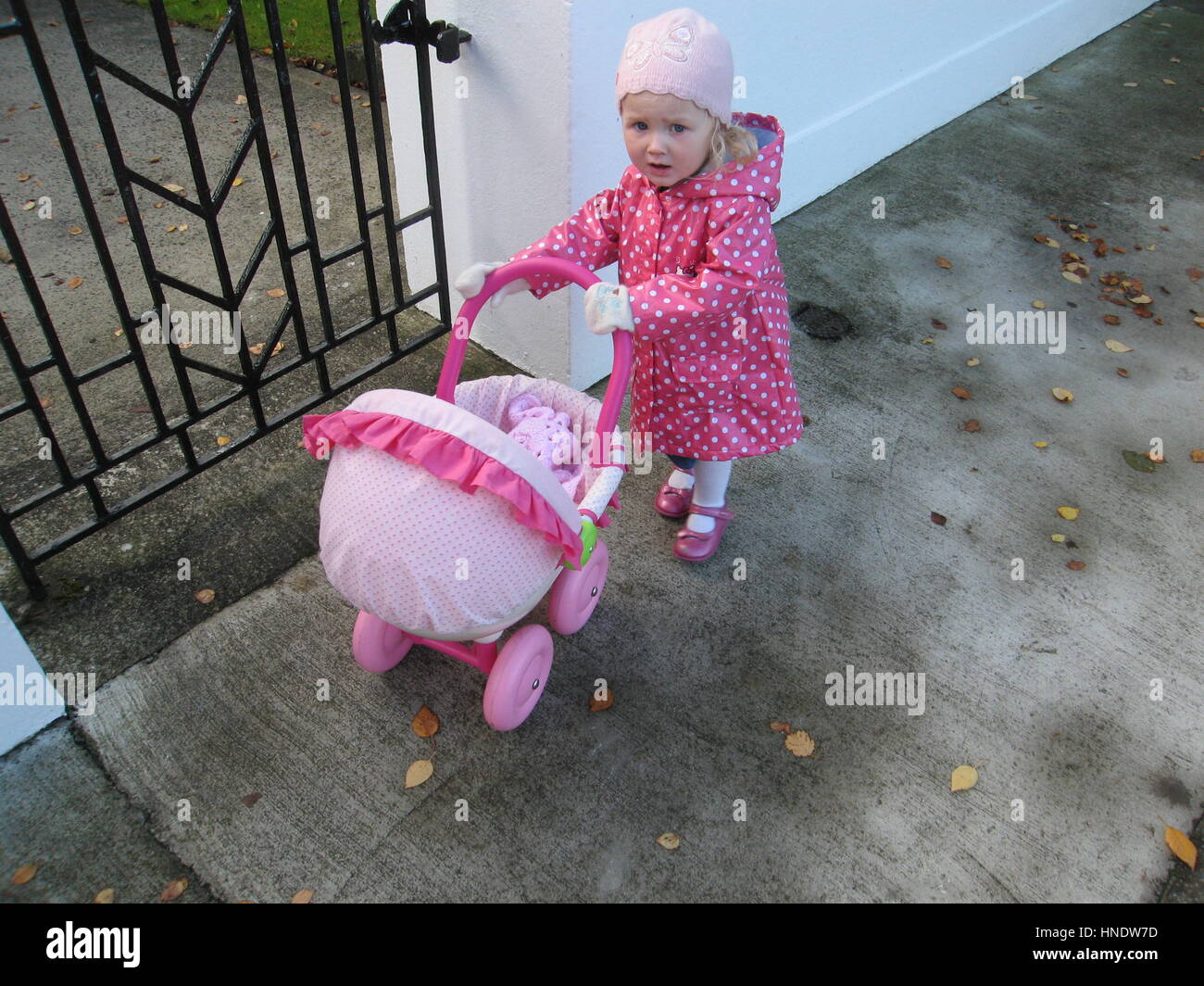 LIttle girl pushing her baby in her pram buggy pram stroller Stock ...