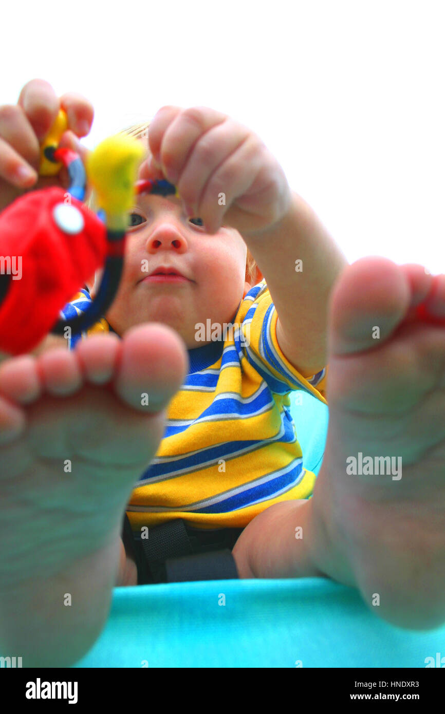 a toddler playing with toys on his toes Stock Photo - Alamy