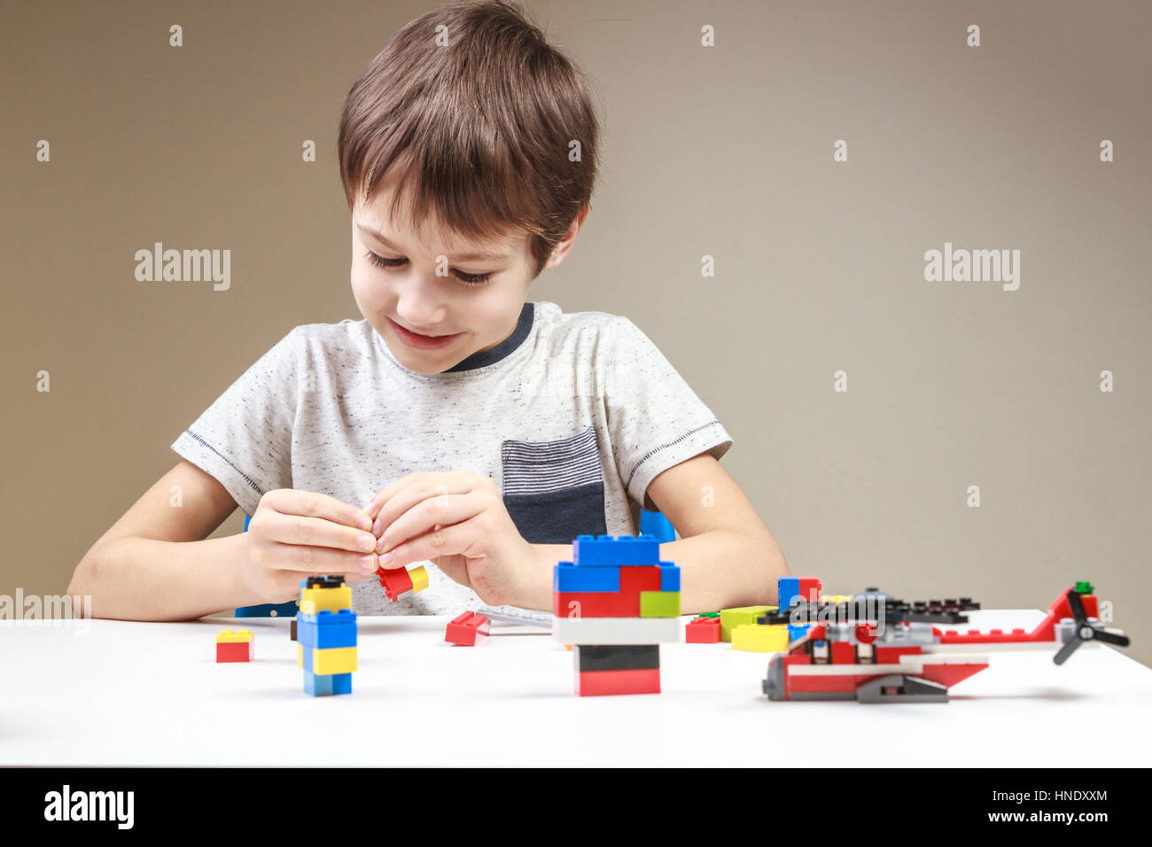 Happy little kid playing with colorful plastic construction bricks at ...