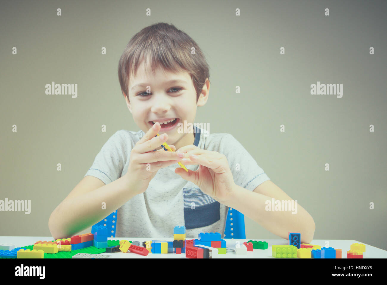 Happy little kid playing with colorful plastic construction bricks at ...