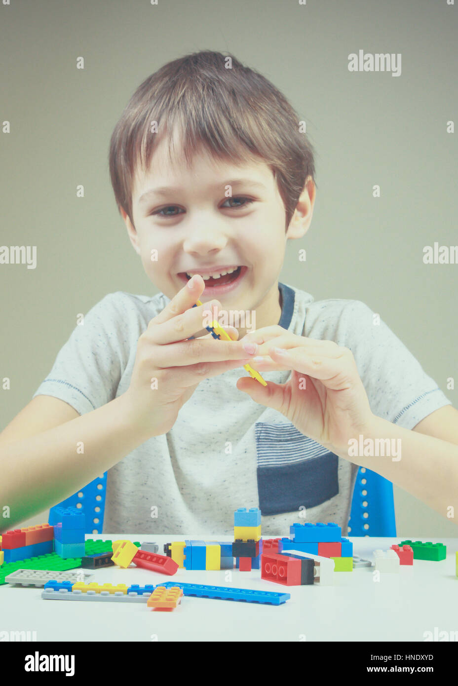 Happy little kid playing with colorful plastic construction bricks at ...