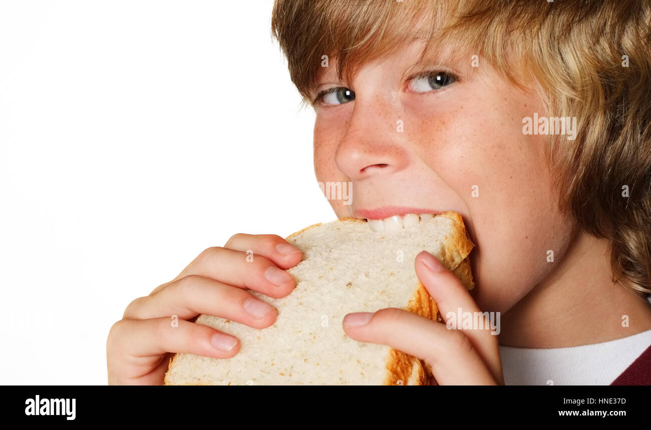 Teen boy eating slice of bread Stock Photo - Alamy