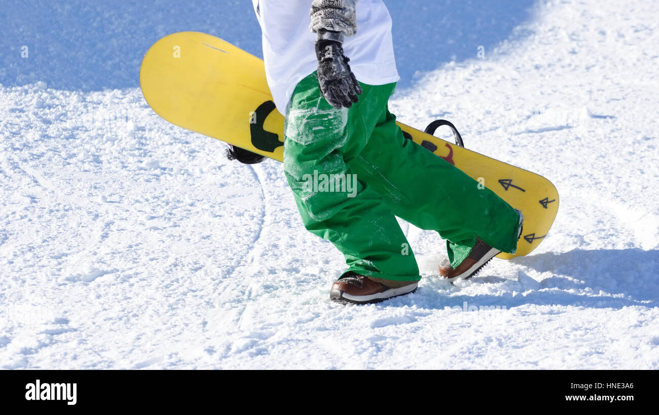 Snowboarder walking with his snowboard Stock Photo - Alamy