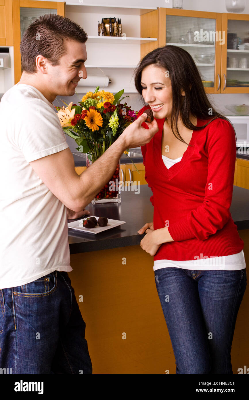 Happy young couple eating strawberries together Stock Photo - Alamy