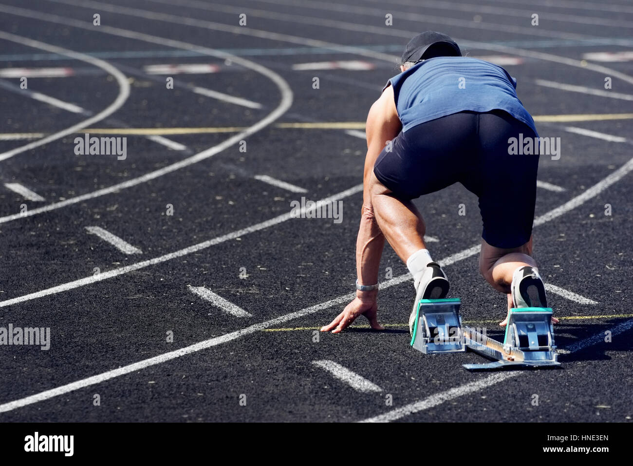 A runner is in the starting blocks on a track Stock Photo - Alamy