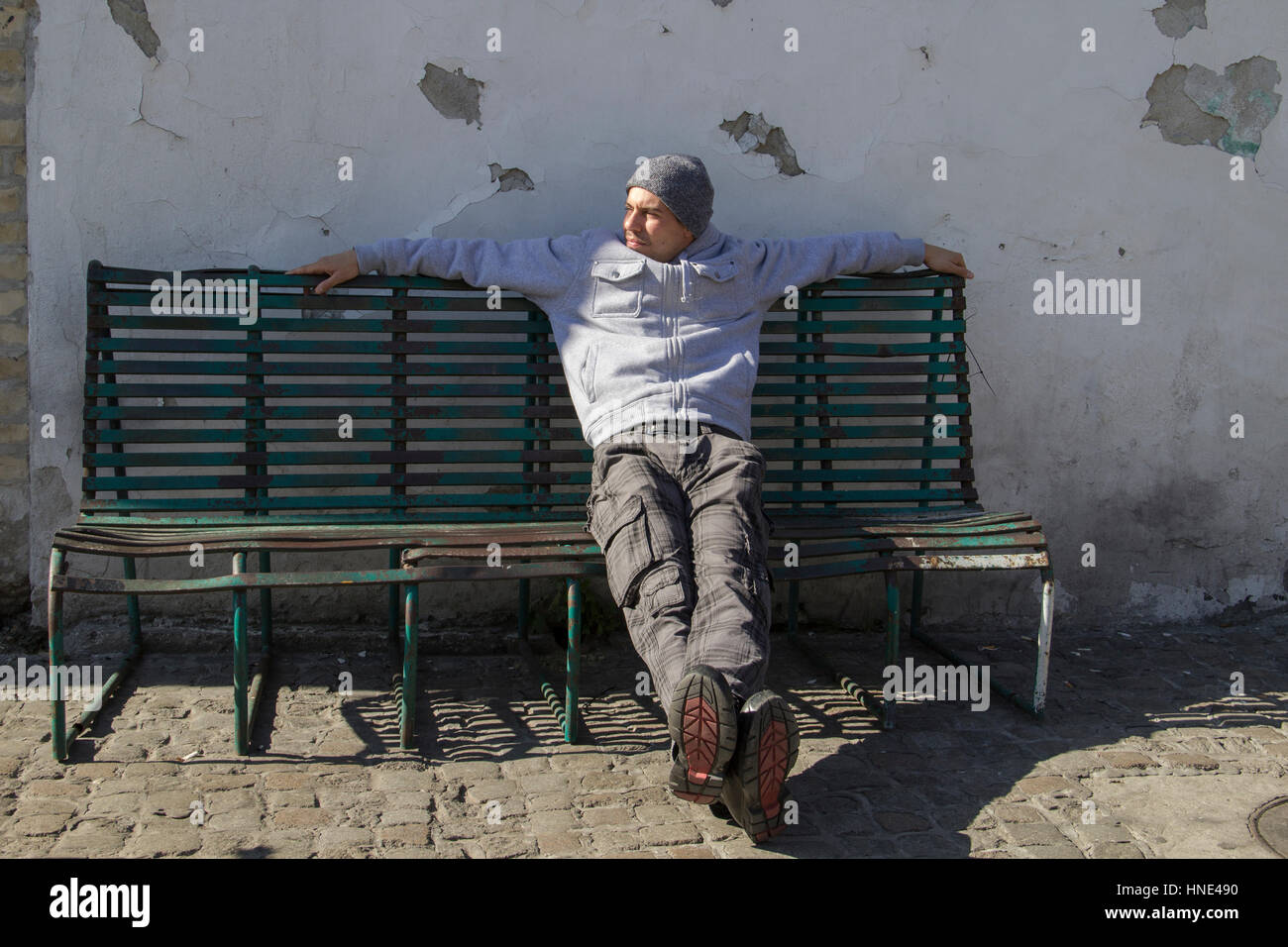 Young Man Sitting On A Bench Stock Photo - Alamy