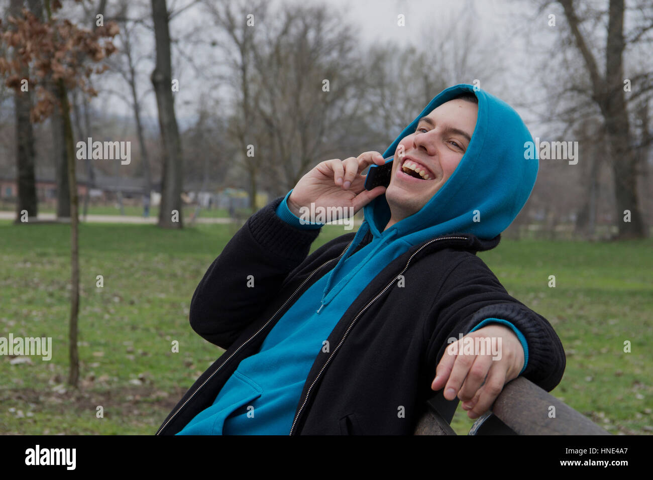 Young Man With A Blue Hood phoning Stock Photo - Alamy