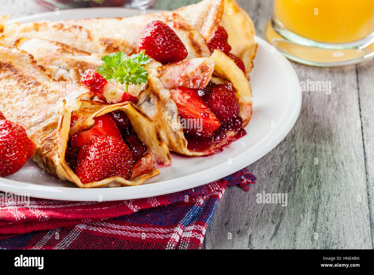 Traditional crepes served with strawberries on a plate Stock Photo - Alamy