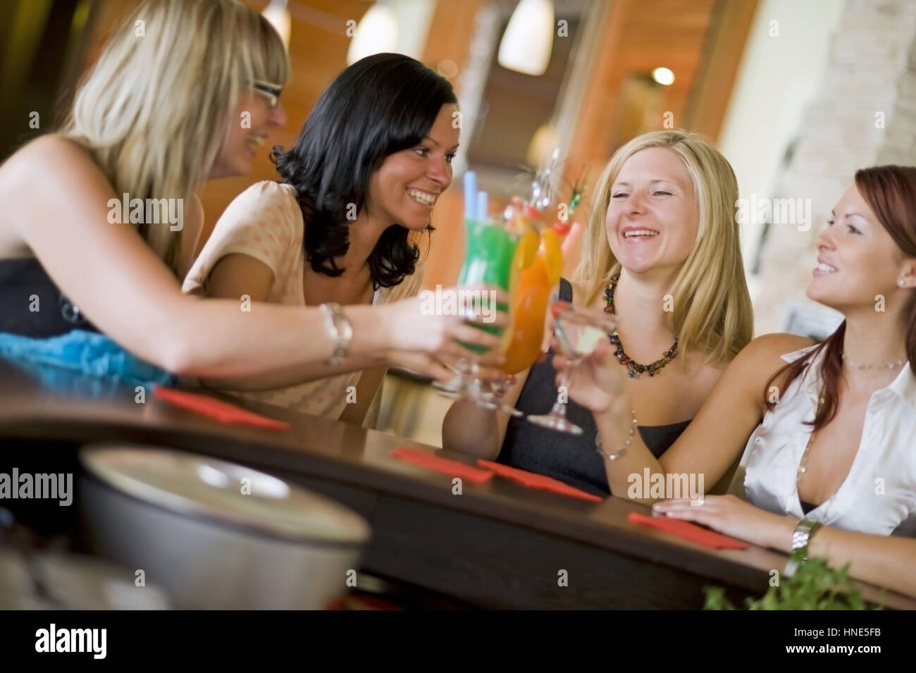 Model release, Vier junge Frauen sitzen mit Cocktails an der Bar - four ...