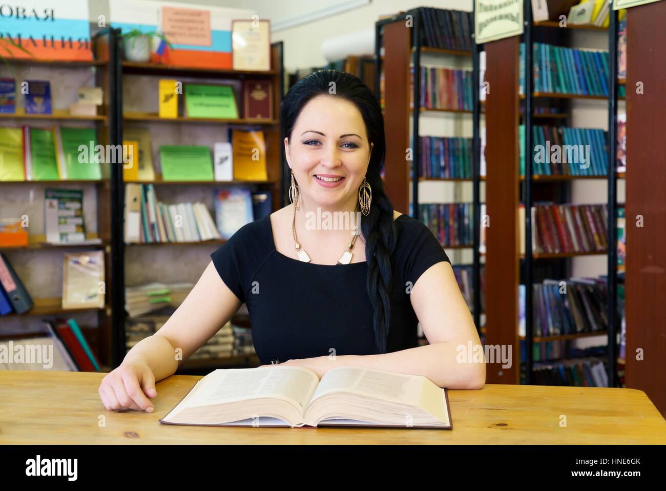 Cute young model girl holding book at library Stock Photo - Alamy