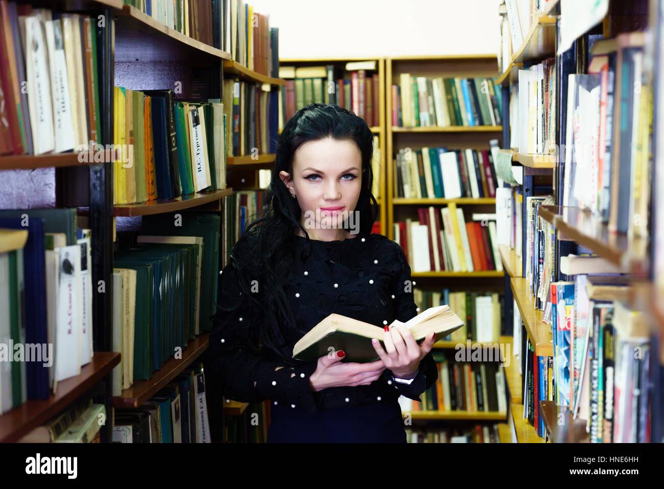 Woman holding book smiling posing for camera Stock Photo - Alamy