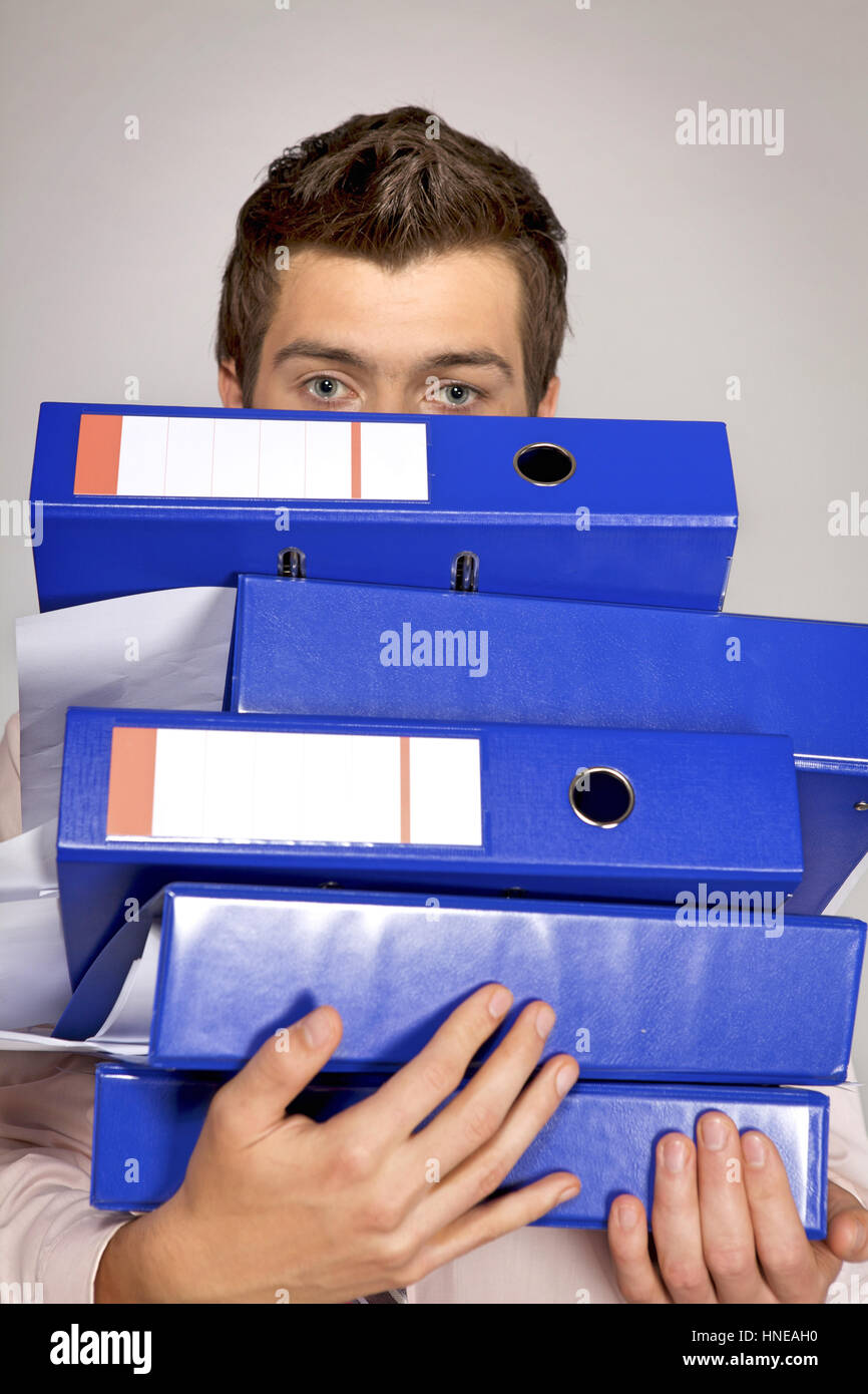 Young caucasian businessman holding a stack of binders Stock Photo - Alamy