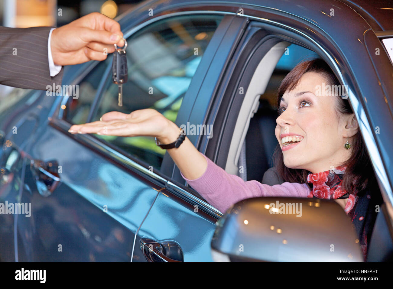 Young woman receiving the car keys from car salesman Stock Photo - Alamy