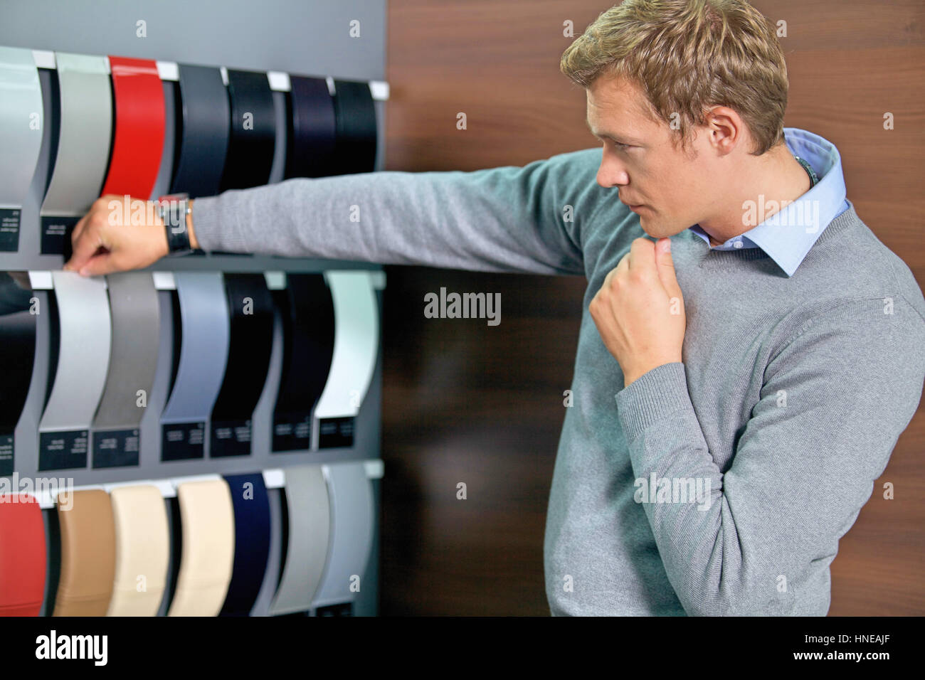 Young man looking at color swatch Stock Photo - Alamy